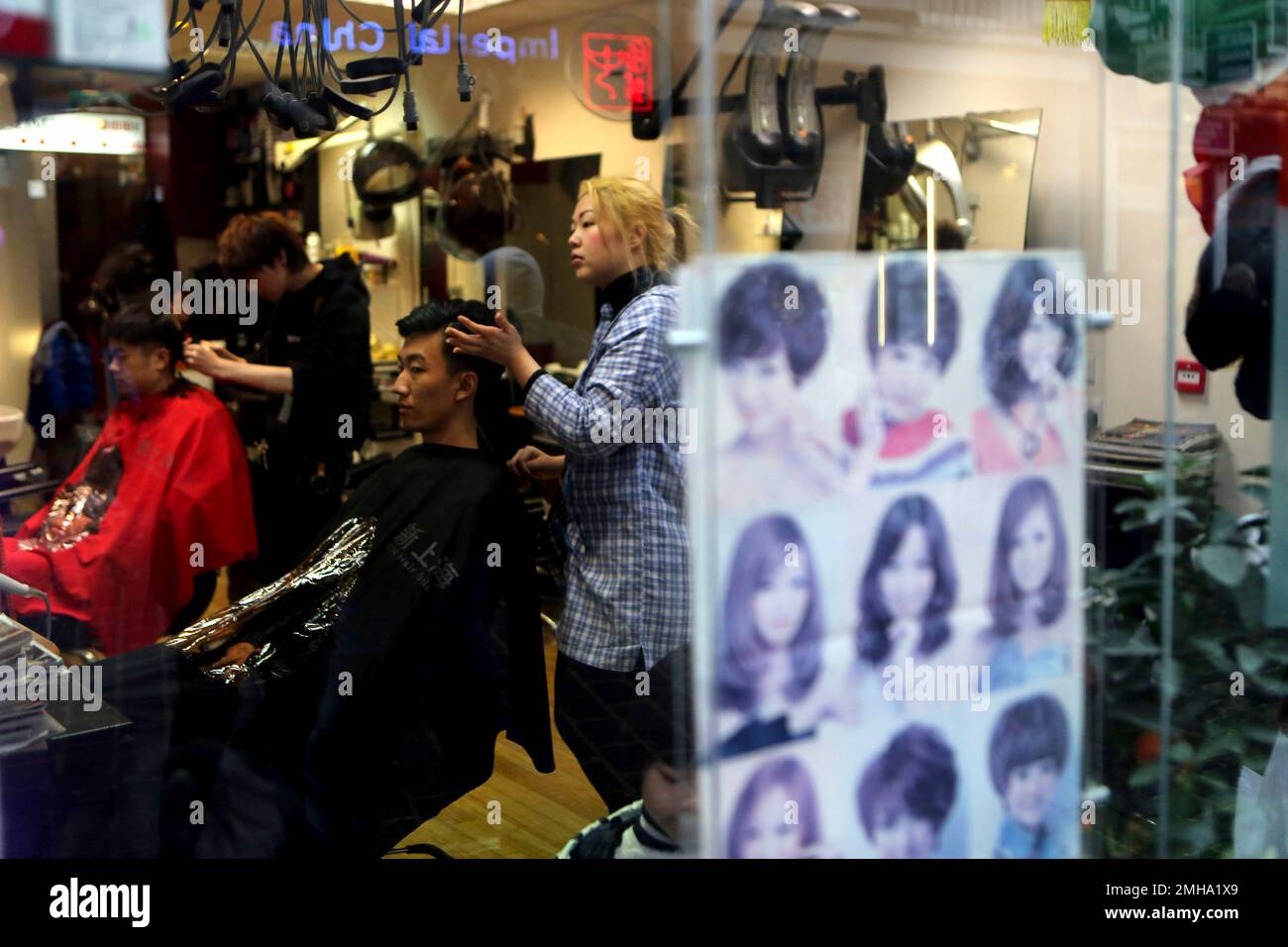 Two men sit at a hairdresser in central London, England, Friday, Dec ...