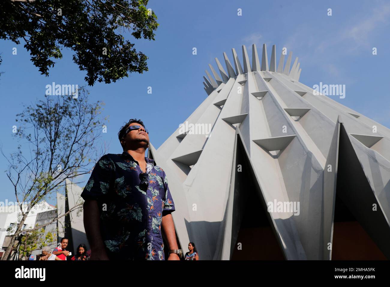 A Sri Lankan man watches a solar eclipse outside the national ...