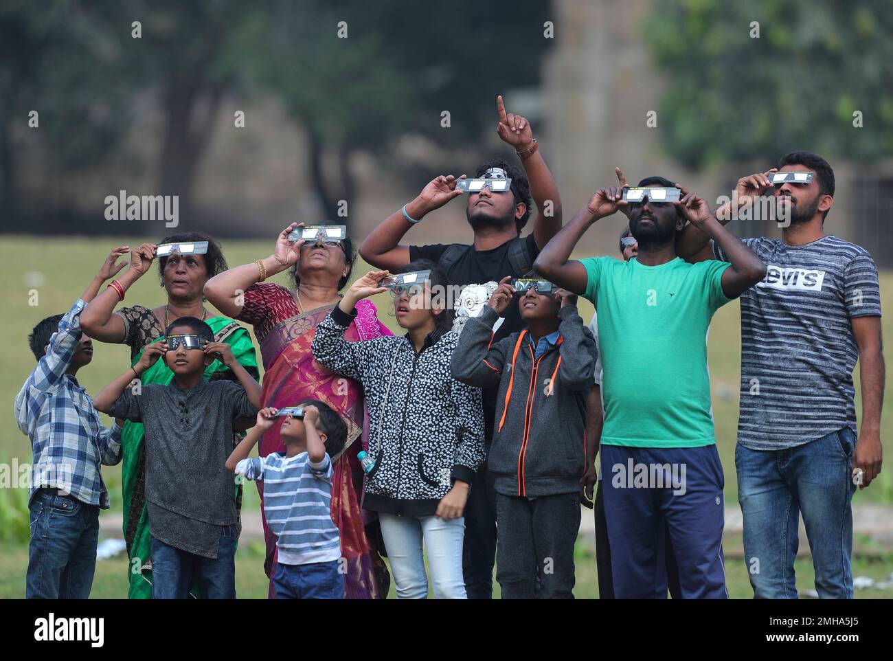 Indians watch a partial solar eclipse in Hyderabad, India, Thursday ...