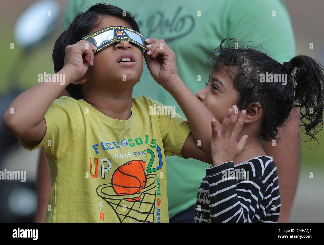 An Indian child watches a partial solar eclipse in Hyderabad, India ...