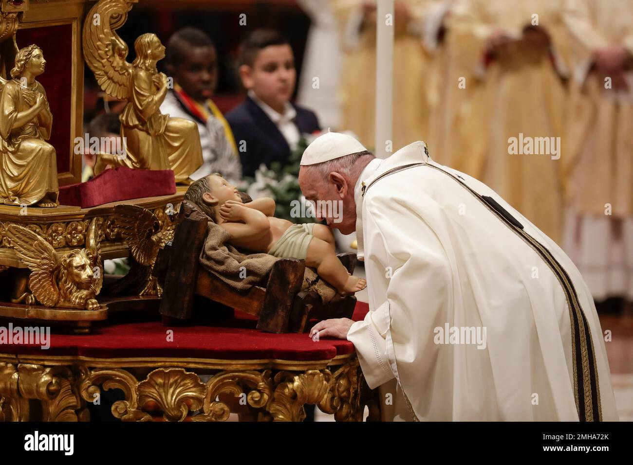 Pope Francis kisses a statue of Baby Jesus as he celebrates Christmas ...
