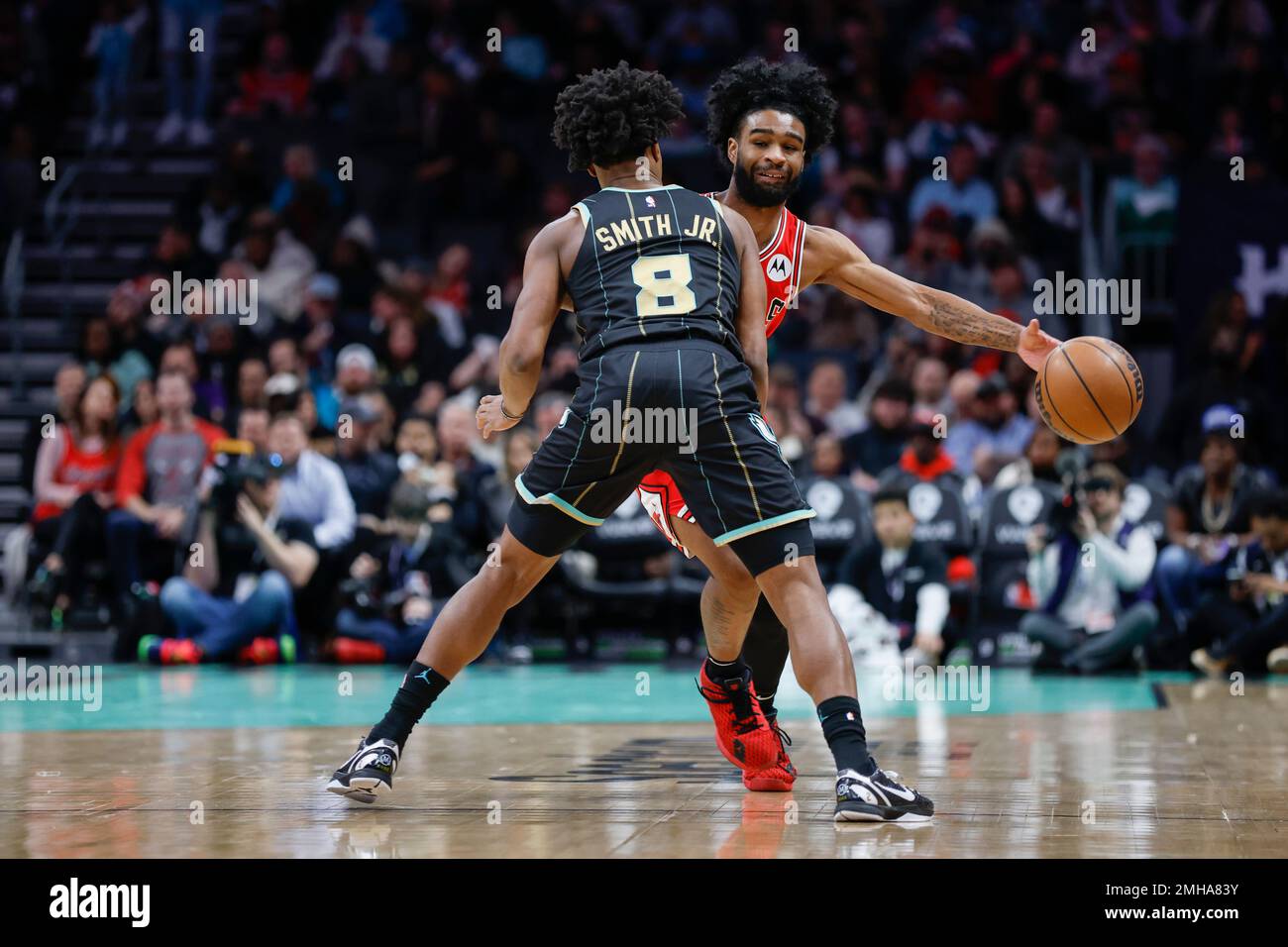 Chicago Bulls guard Coby White, right passes the ball around Charlotte ...