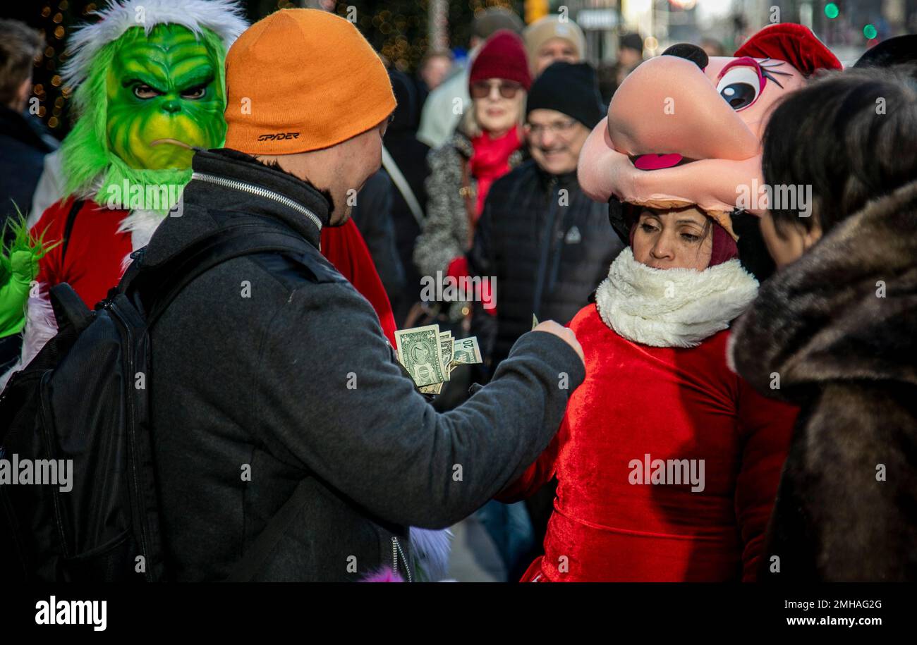 In this Friday, Dec. 20, 2019 photo, costumed Grinch and Minnie Mouse ...