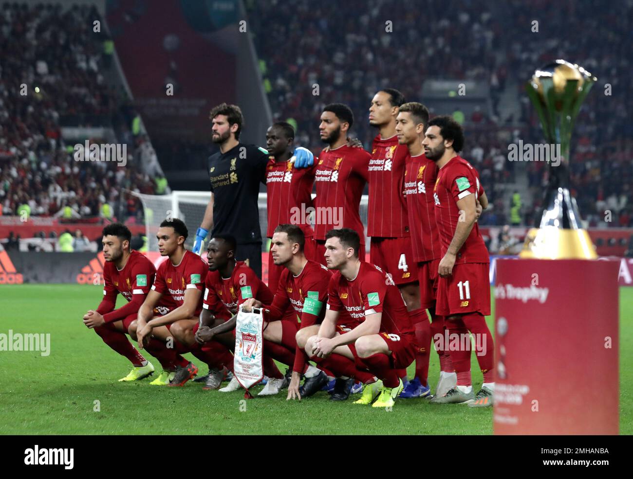Players of Liverpool line up next to the trophy for winners of the Club ...