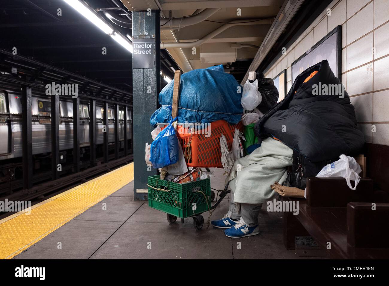 A homeless person sleeps on a subway station bench, Friday, Dec. 20 ...