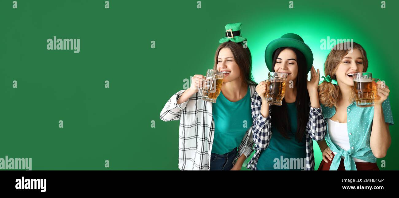 Young women drinking beer on green background with space for text. St ...
