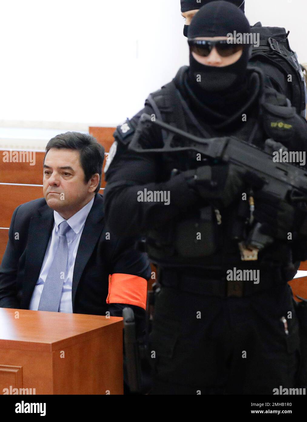 Marian Kocner sits surrounded by armed police officers in a courtroom ...