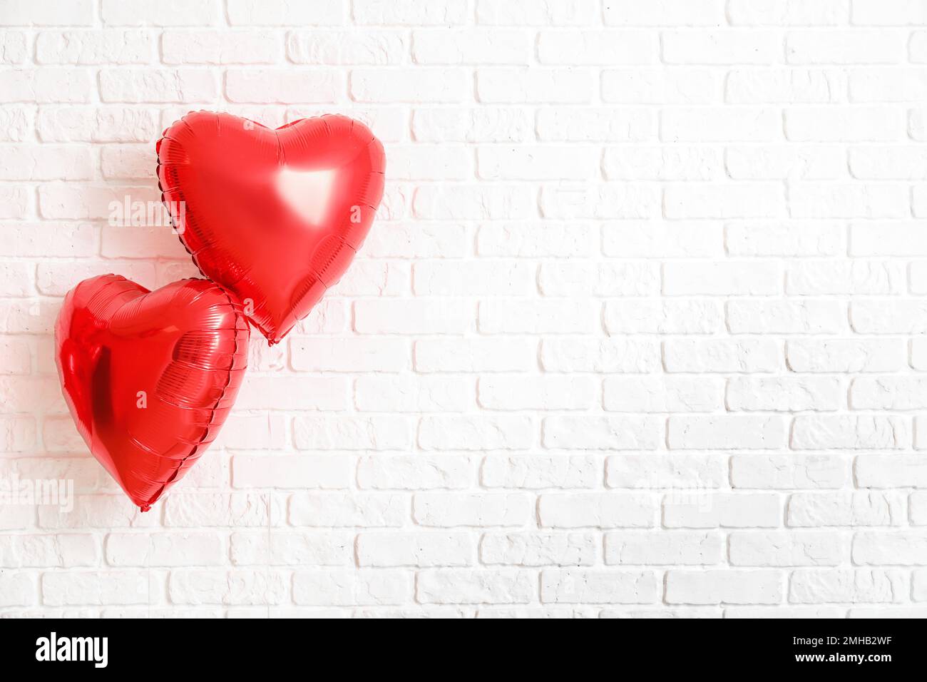 Heart shaped balloons for Valentine's Day on white brick background ...