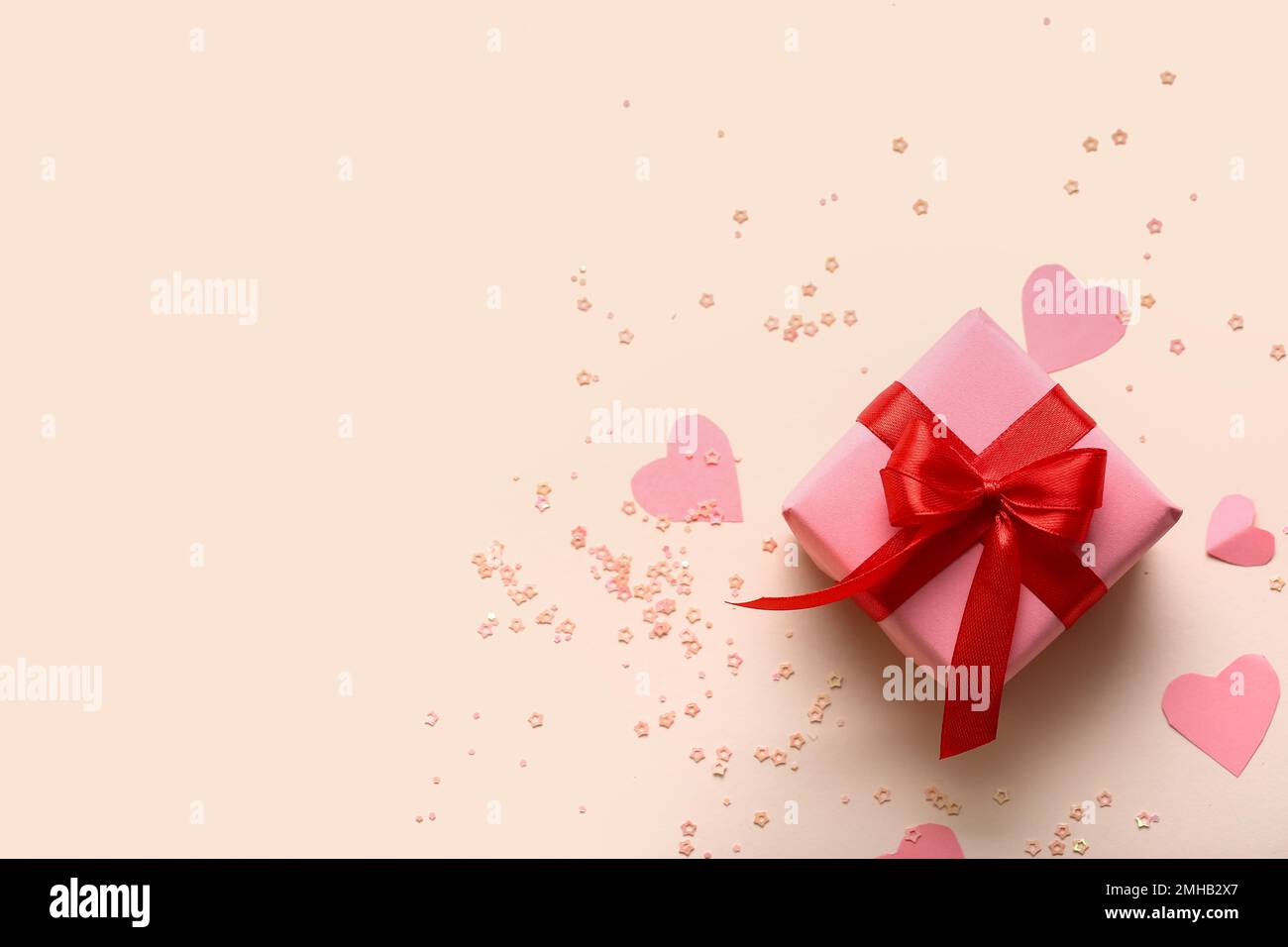 Composition with gift box, paper decor and sequins on color background ...