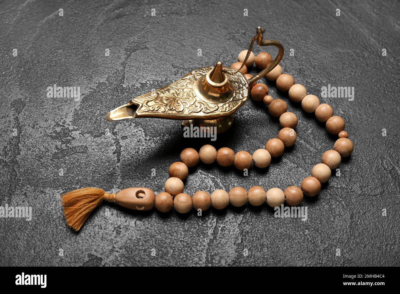 Aladdin lamp of wishes and prayer beads for Ramadan on dark background ...