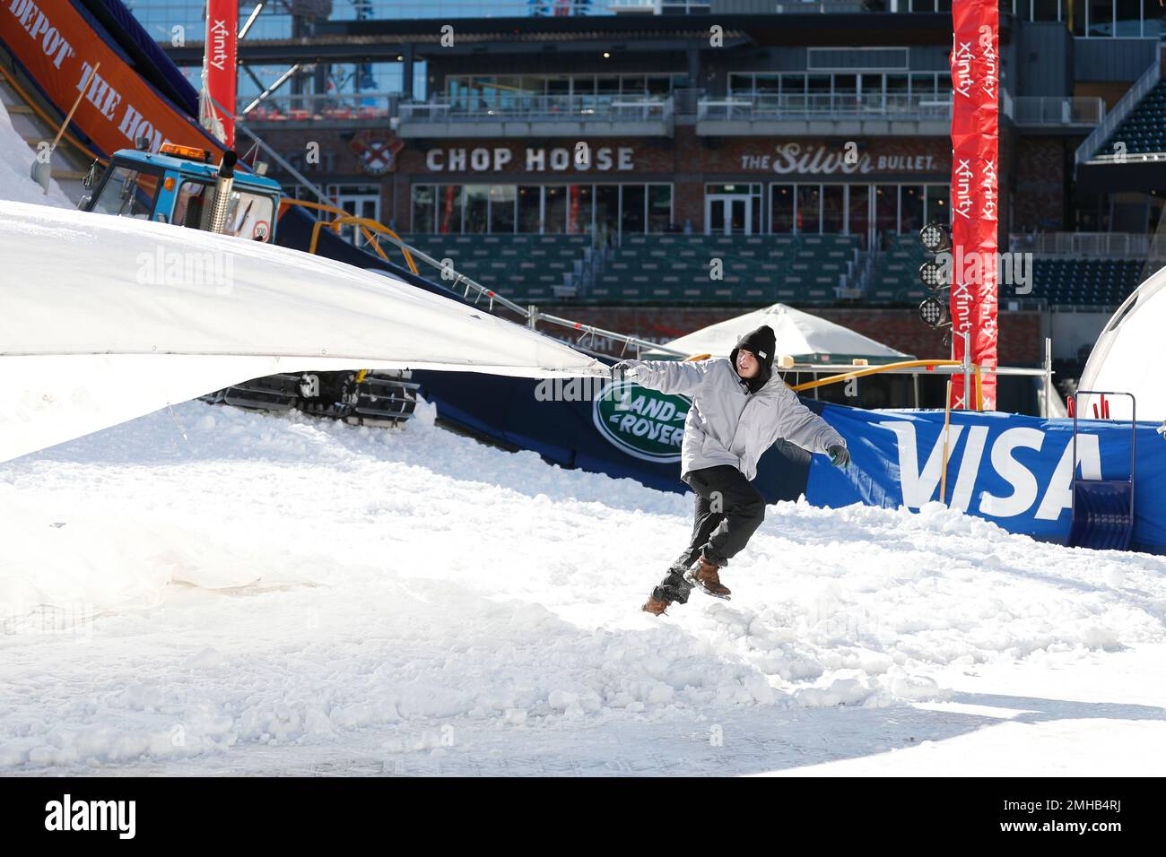 Crews work to construct and cover a giant ski slope with snow on the ...