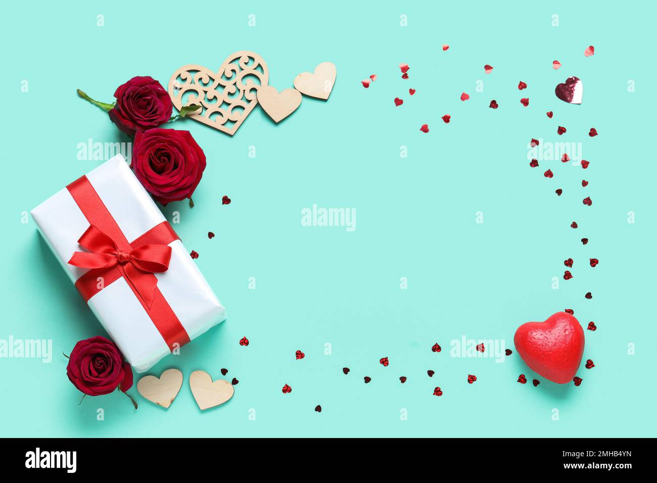 Frame made of gift box, hearts and rose flowers on turquoise background ...