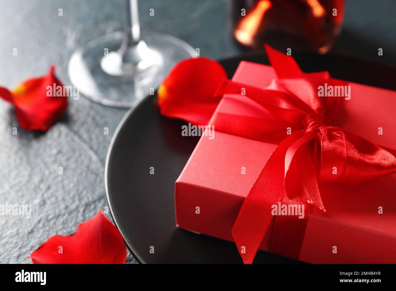 Plate with beautiful gift for Valentine's Day celebration on dark color ...