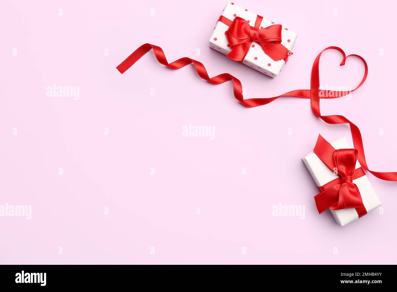 Gifts and heart made of red satin ribbon on pink background. Valentine ...