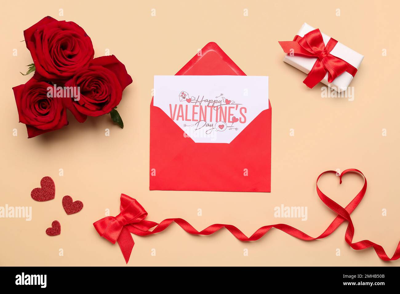 Composition with greeting card in envelope, rose flowers and heart made ...