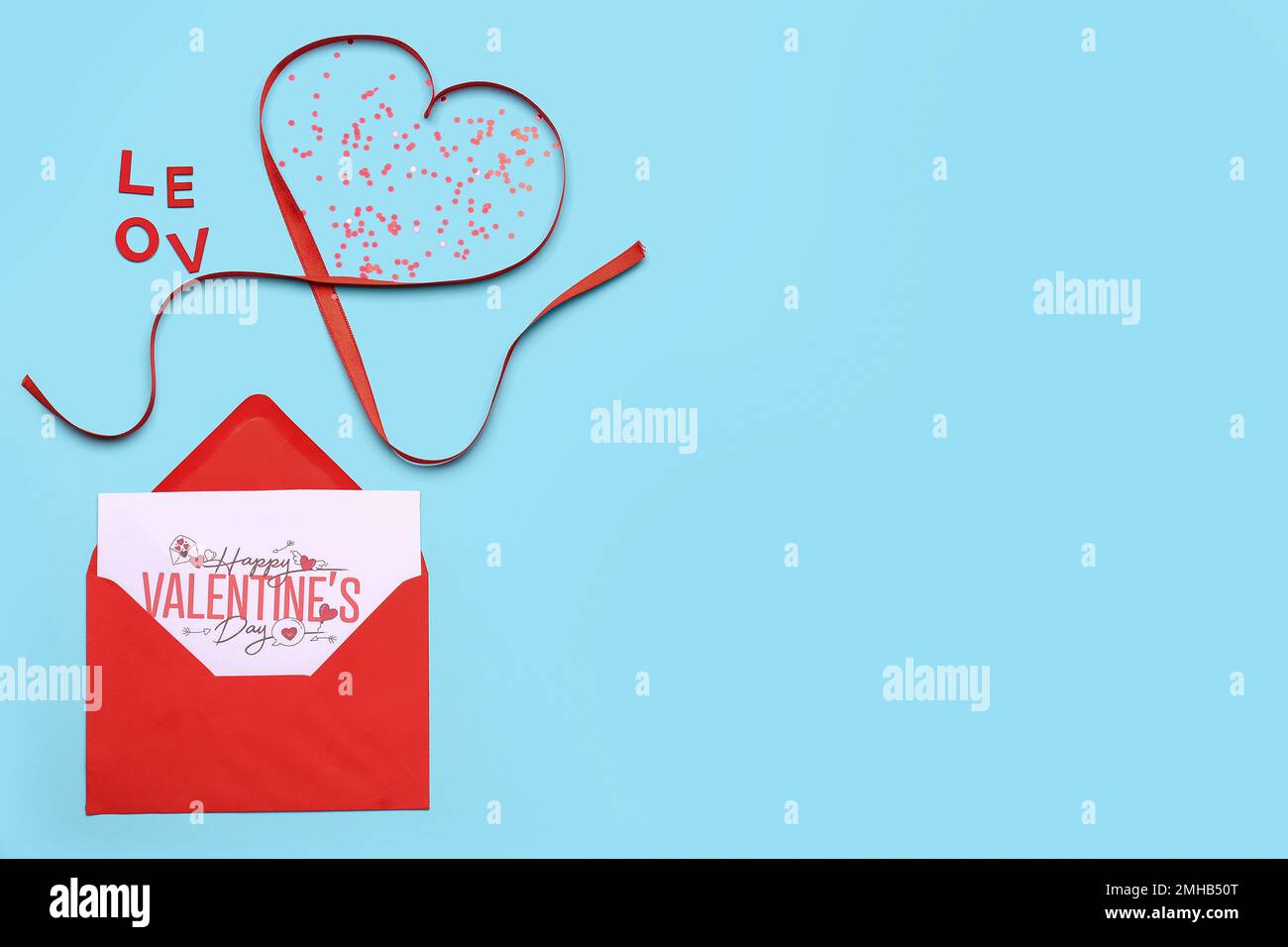 Word LOVE, greeting card in envelope and heart made of red satin ribbon ...