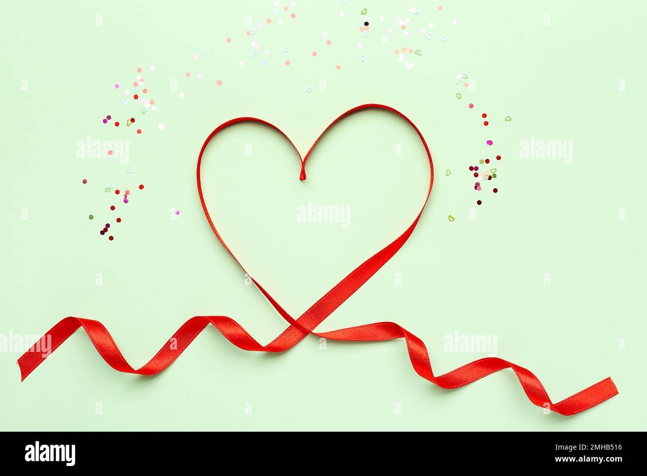 Heart made of red satin ribbon on green background. Valentine's Day ...