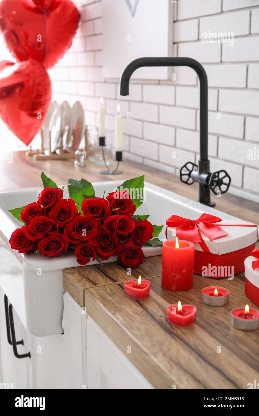 Sink with roses, wine glasses, burning candles and gifts for Valentine ...