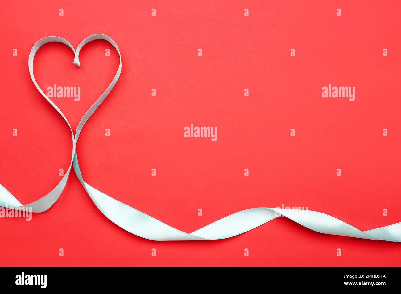 Heart made of turquoise satin ribbon on red background. Valentine's Day ...