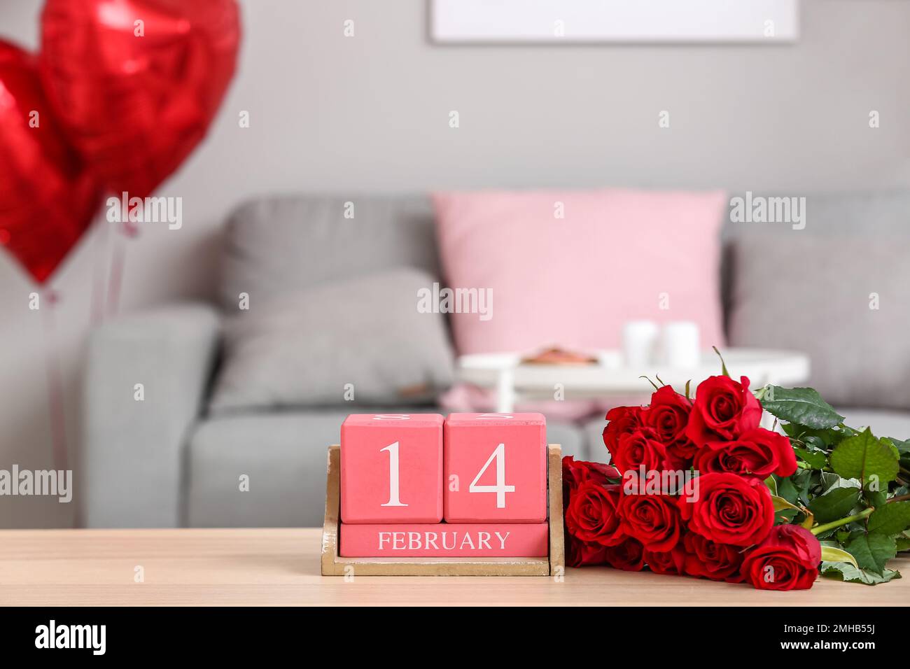 Calendar with date 14 FEBRUARY and roses on table in living room ...