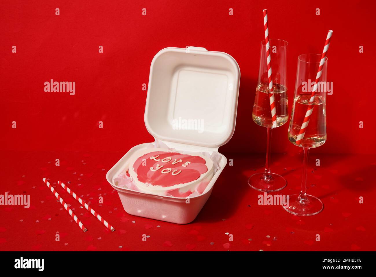 Lunch box with bento cake, glasses of champagne and straws for ...