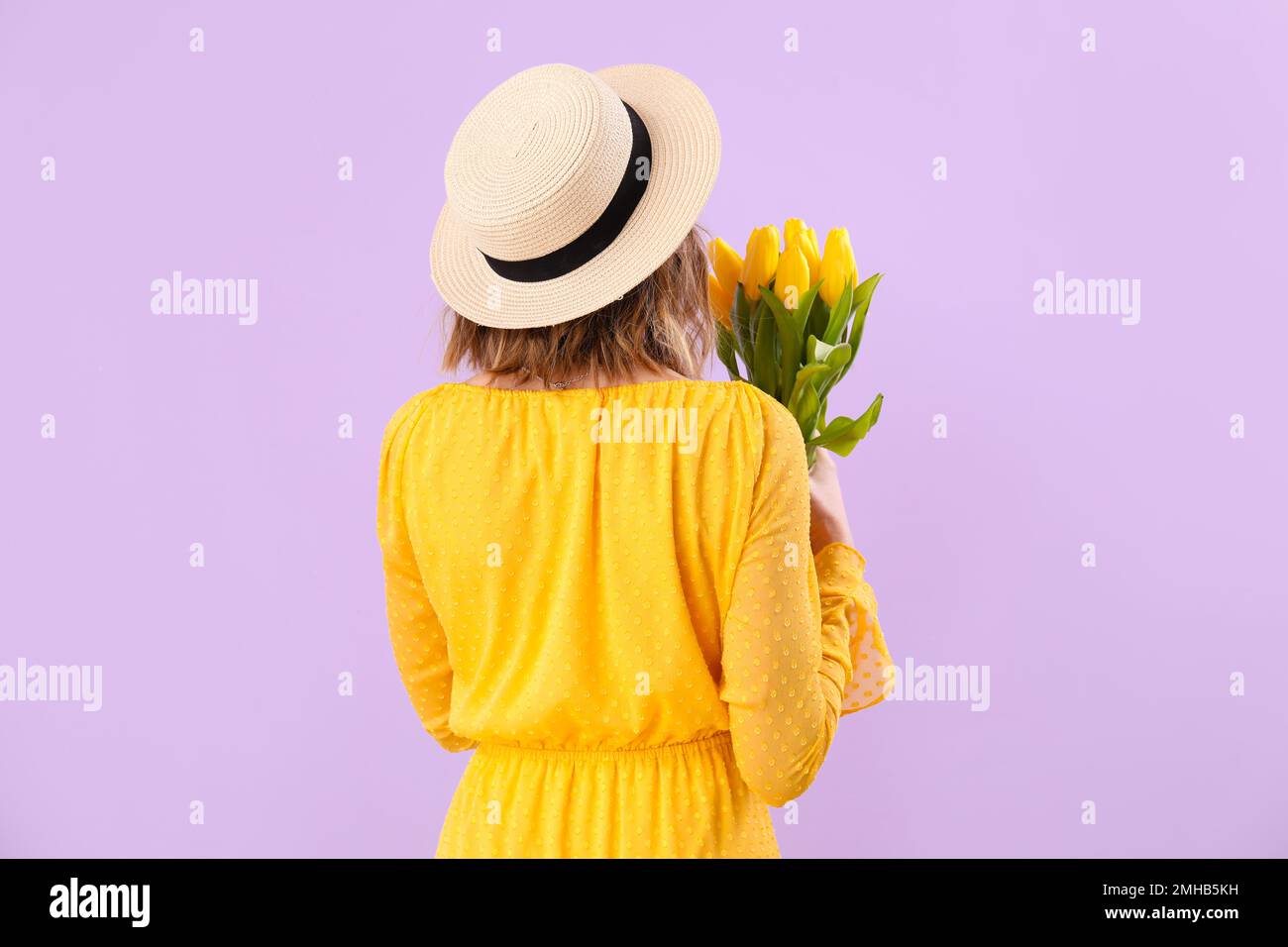 Beautiful happy young woman with bouquet of tulips on lilac background ...