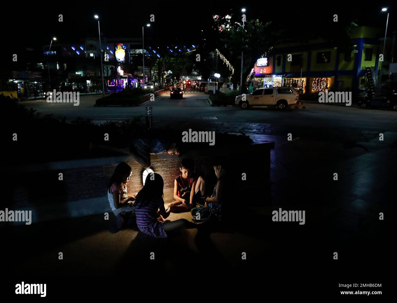 Children play beside a street lamp in Quezon city, Metro Manila ...