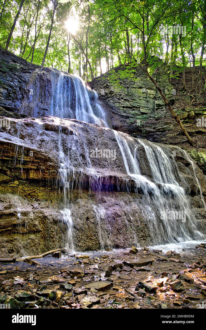 Low-angle view of a waterfall with lens flare Stock Photo - Alamy