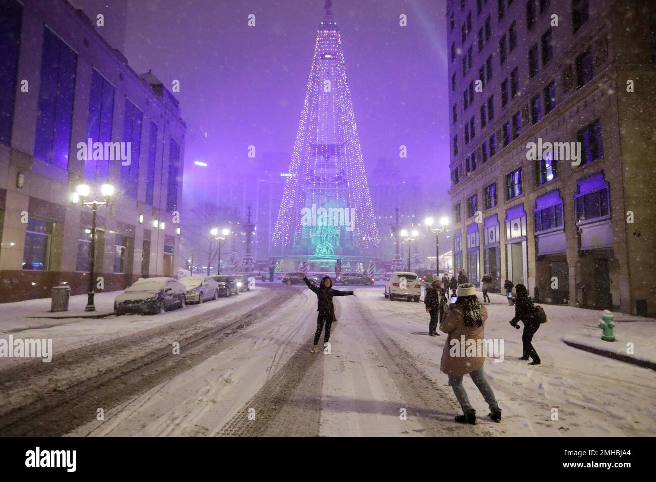 People pose for photos as snow falls in downtown Indianapolis, Sunday ...