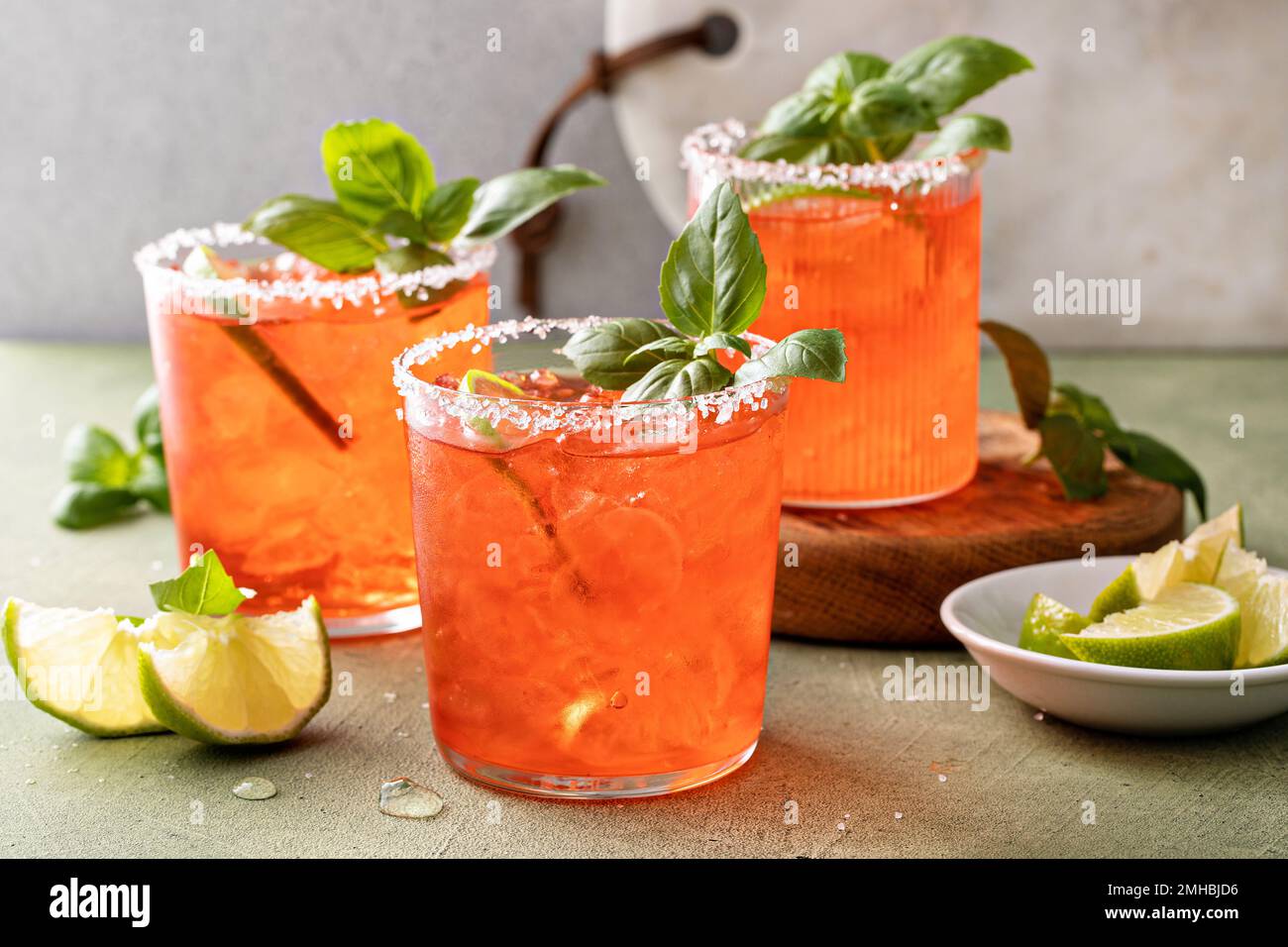 Strawberry basil margarita with lime wedges on the table Stock Photo ...