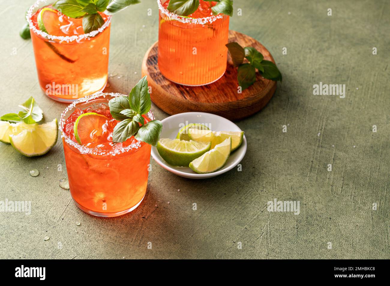 Strawberry basil margarita with lime wedges on the table Stock Photo ...