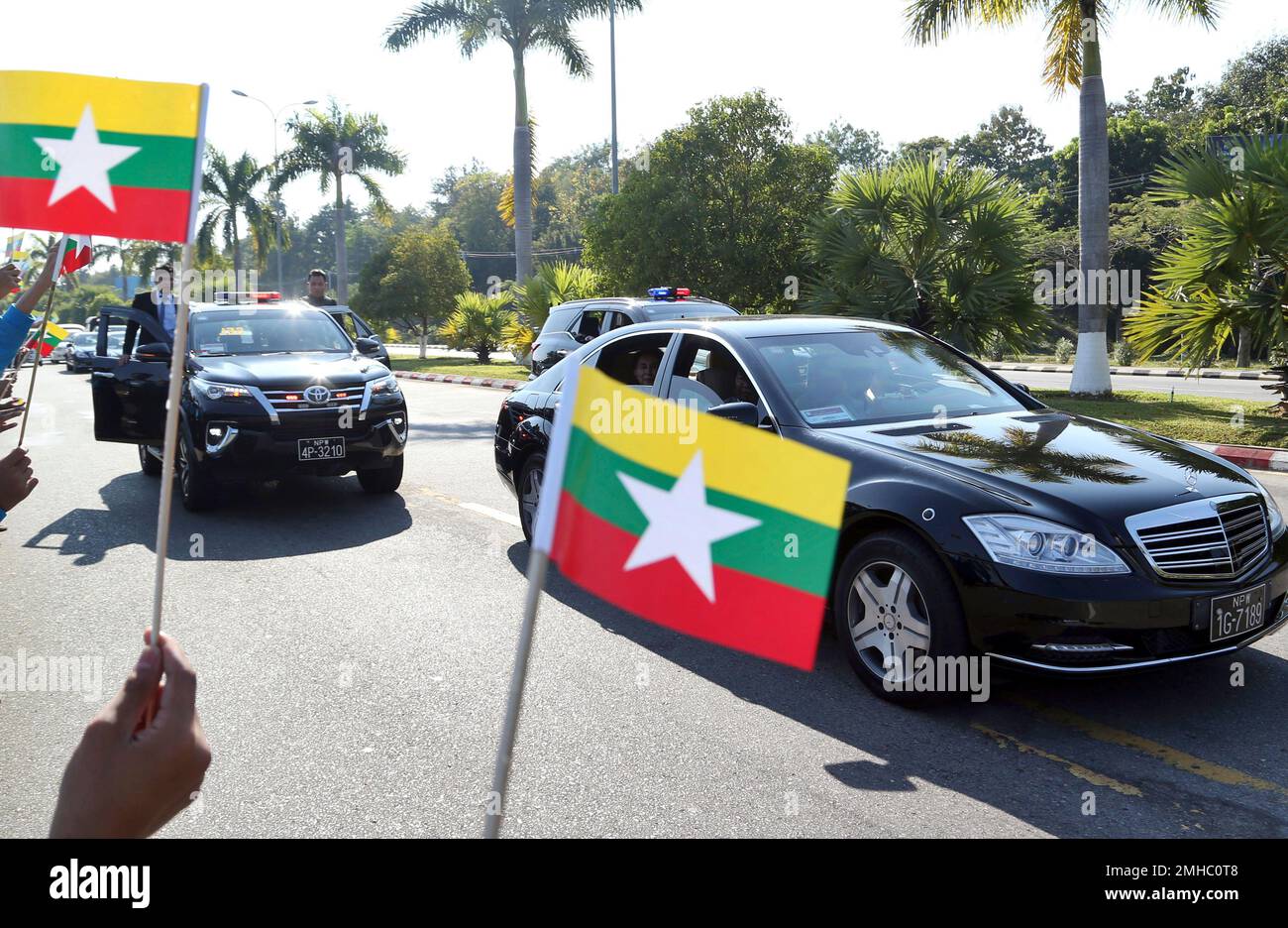 Myanmar Leader Aung San Suu Kyi smiles as supporters wav Myanmarese ...