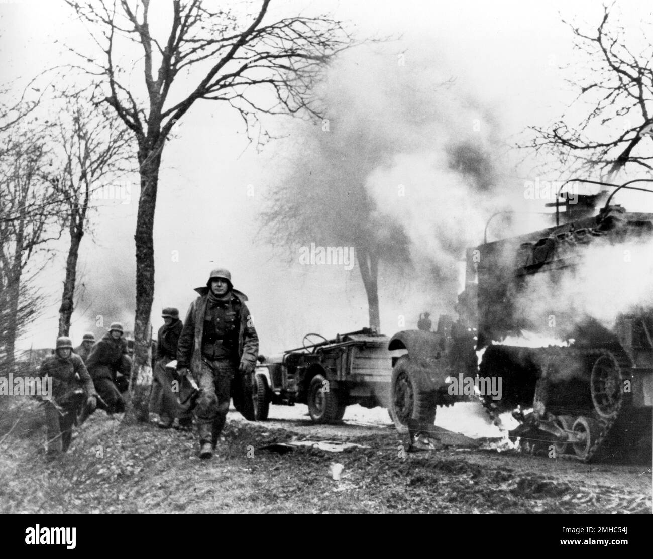 FILE - In this Dec. 1944 file photo, German infantrymen pass by burning ...