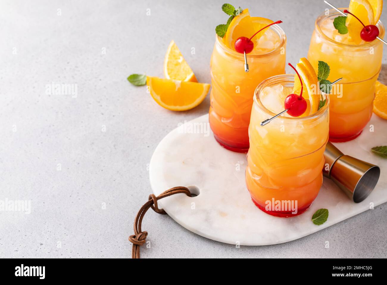 Rum punch in tiki glasses with orange slices and a cherry Stock Photo ...