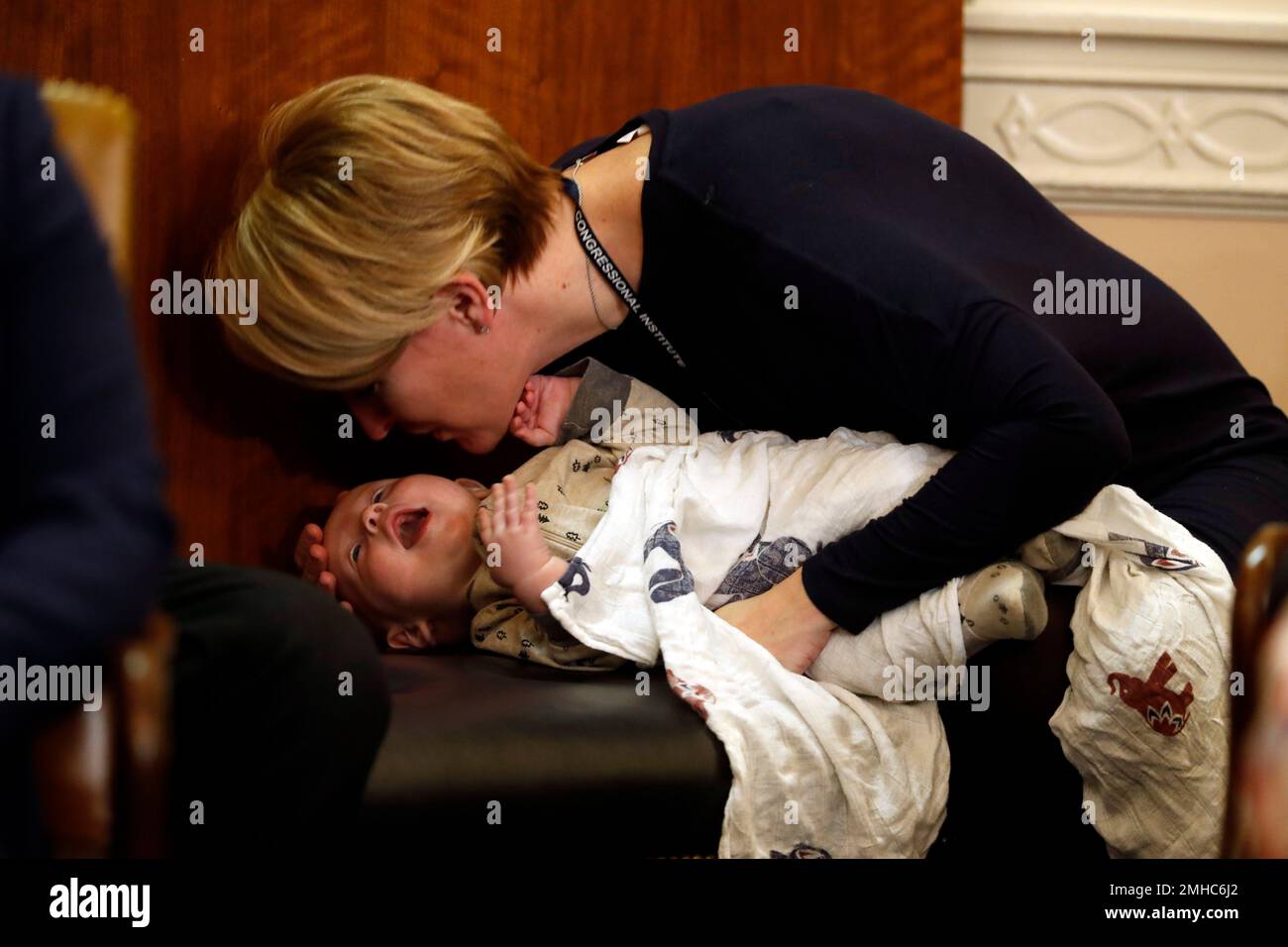 Staff member Machalagh Carr kisses her 4-month-old Lachlan in the room ...