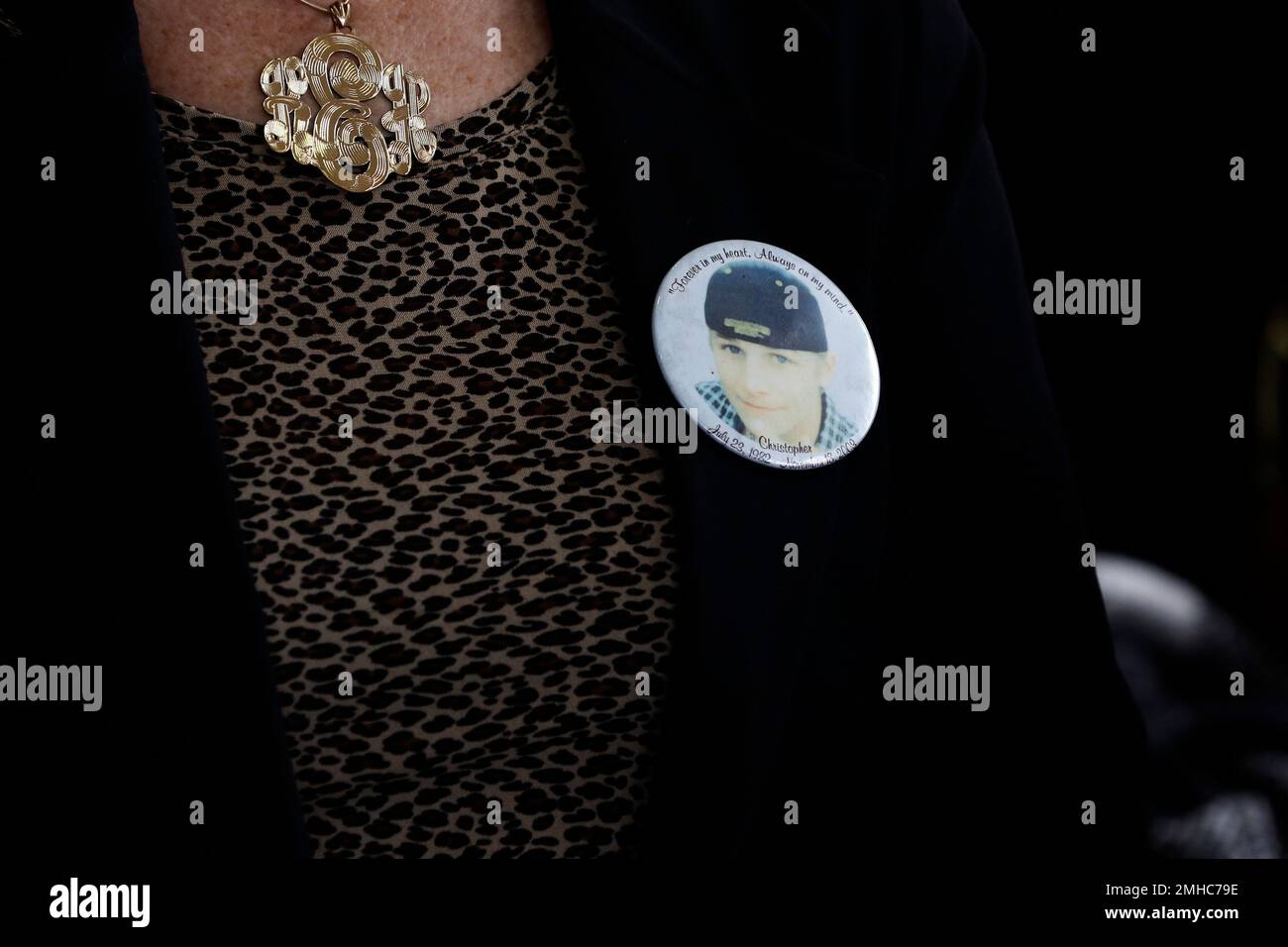 Karren Ewing wears a button photograph of her late son, Christopher ...
