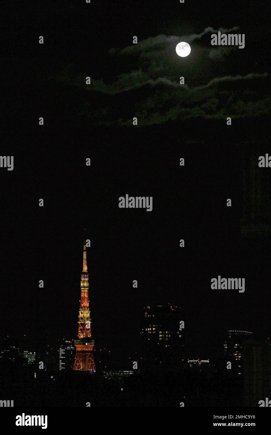 The full moon rises over Tokyo Tower Thursday, Dec. 12, 2019, in Tokyo ...