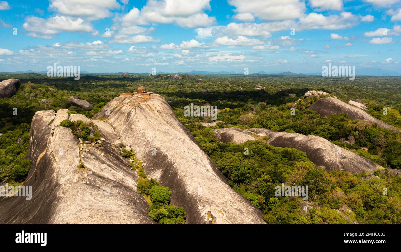 Aerial view of Rocks among the rainforest and jungle against the blue sky and clouds. Sri Lanka ...