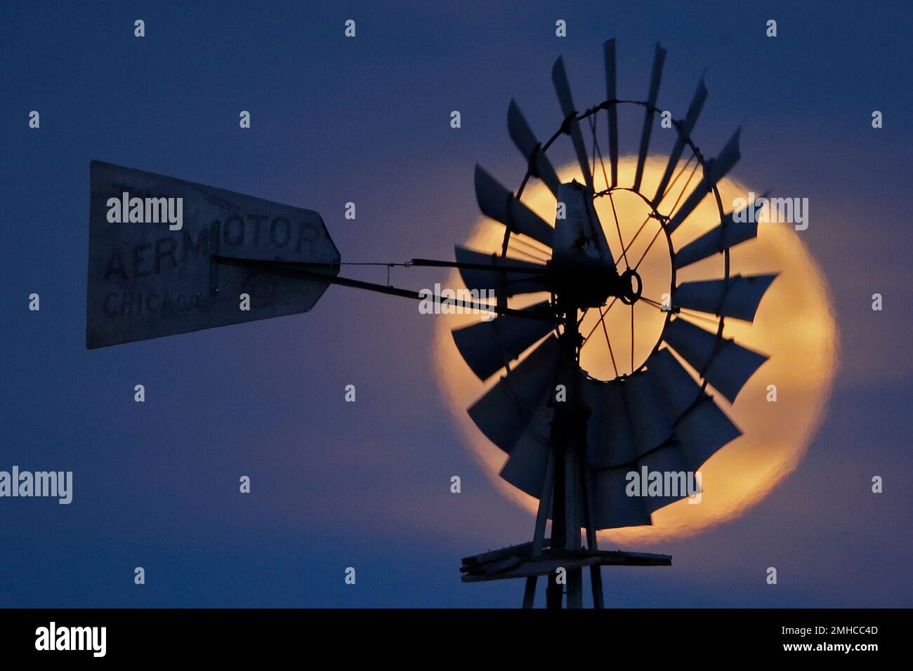The full moon rises beyond an old windmill Wednesday, Dec. 11, 2019 ...
