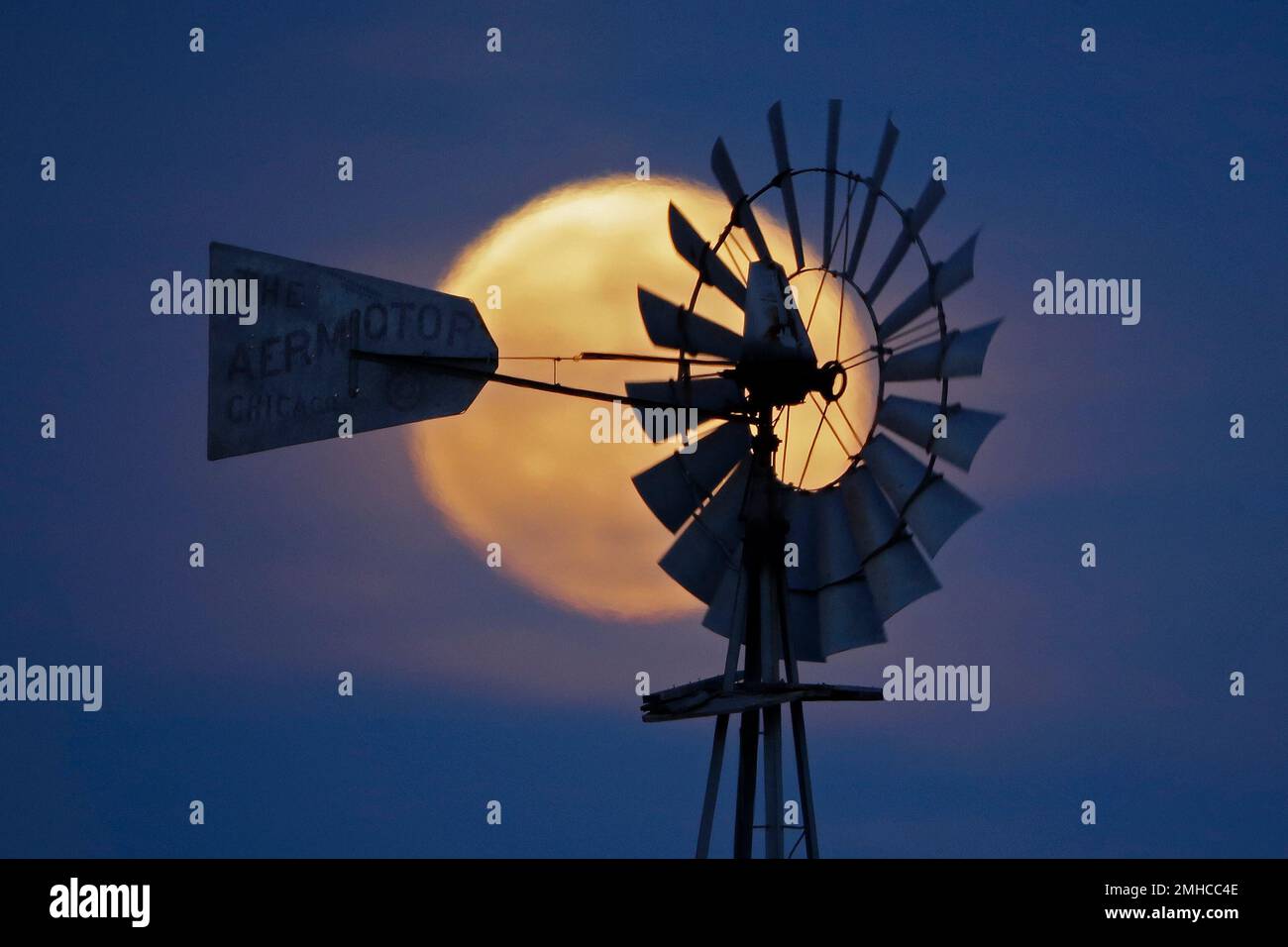 The full moon rises beyond an old windmill Wednesday, Dec. 11, 2019 ...