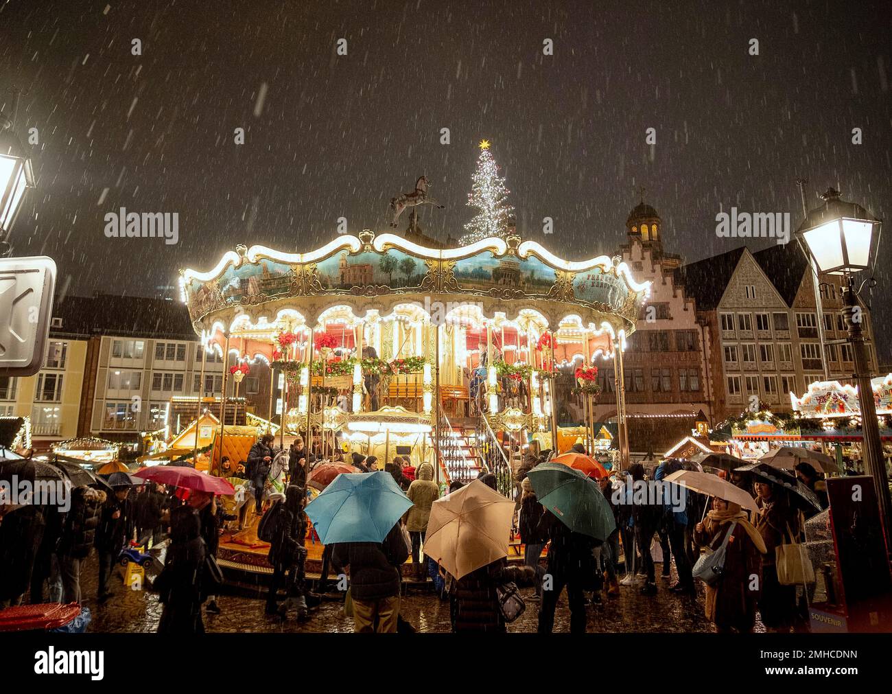 The merry-go-round of the Christmas market is seen during rain and snow ...