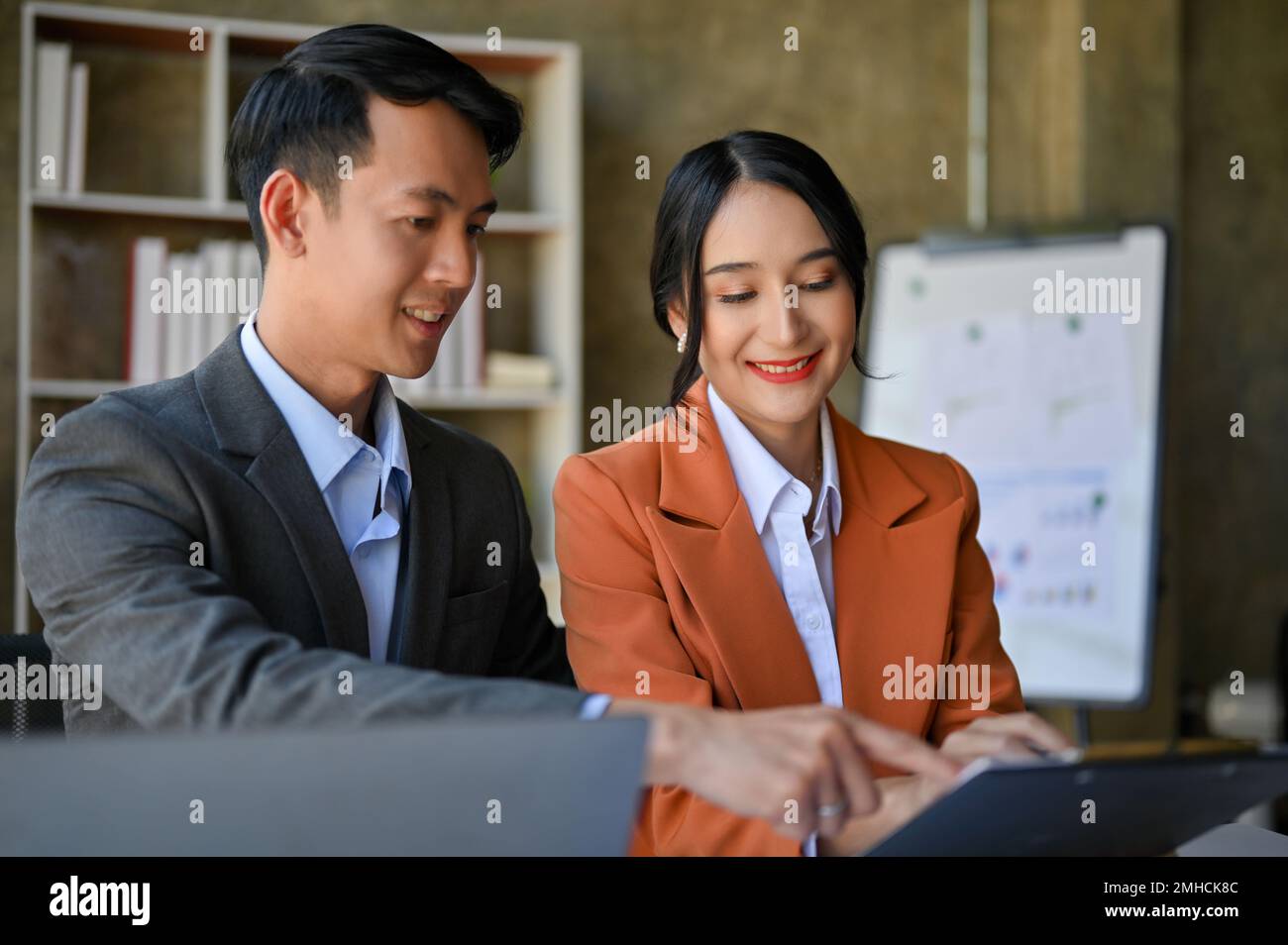 Two professional millennial Asian businesspeople working together in ...