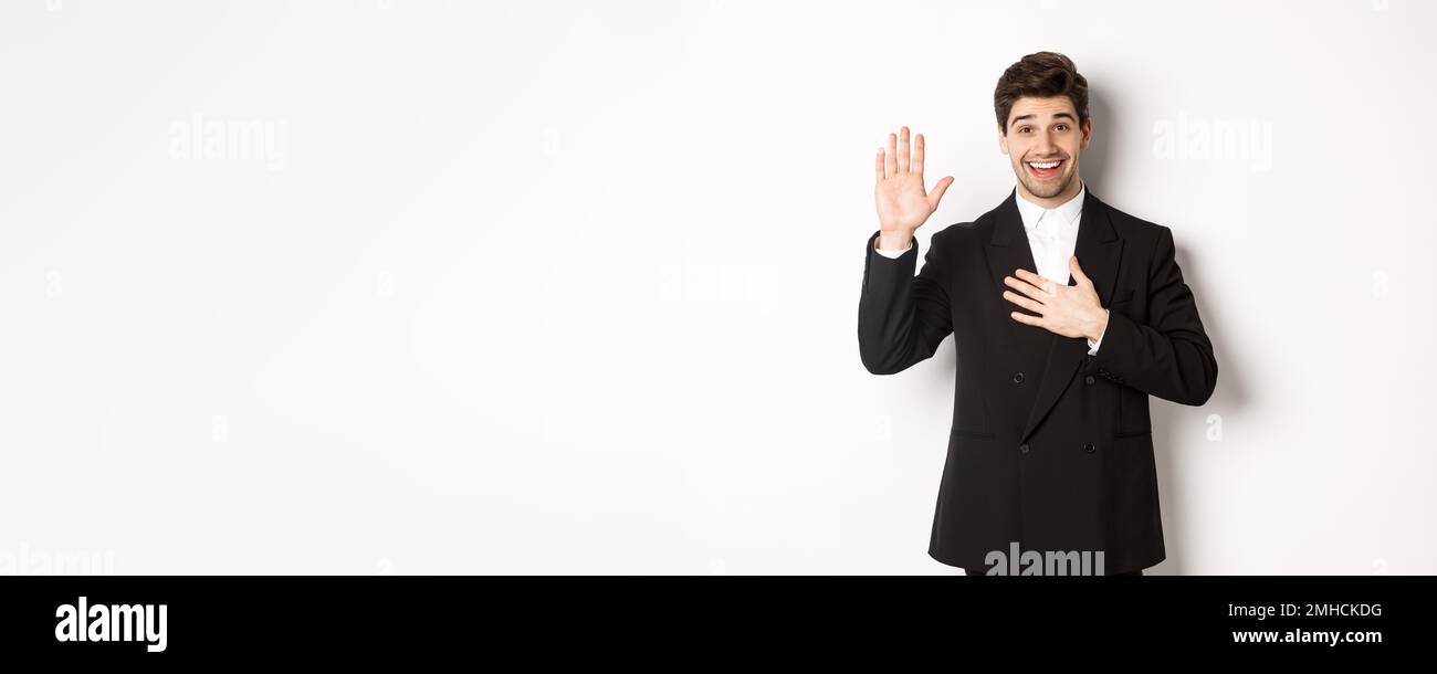 Image of handsome smiling guy telling the truth, raising on arm to ...