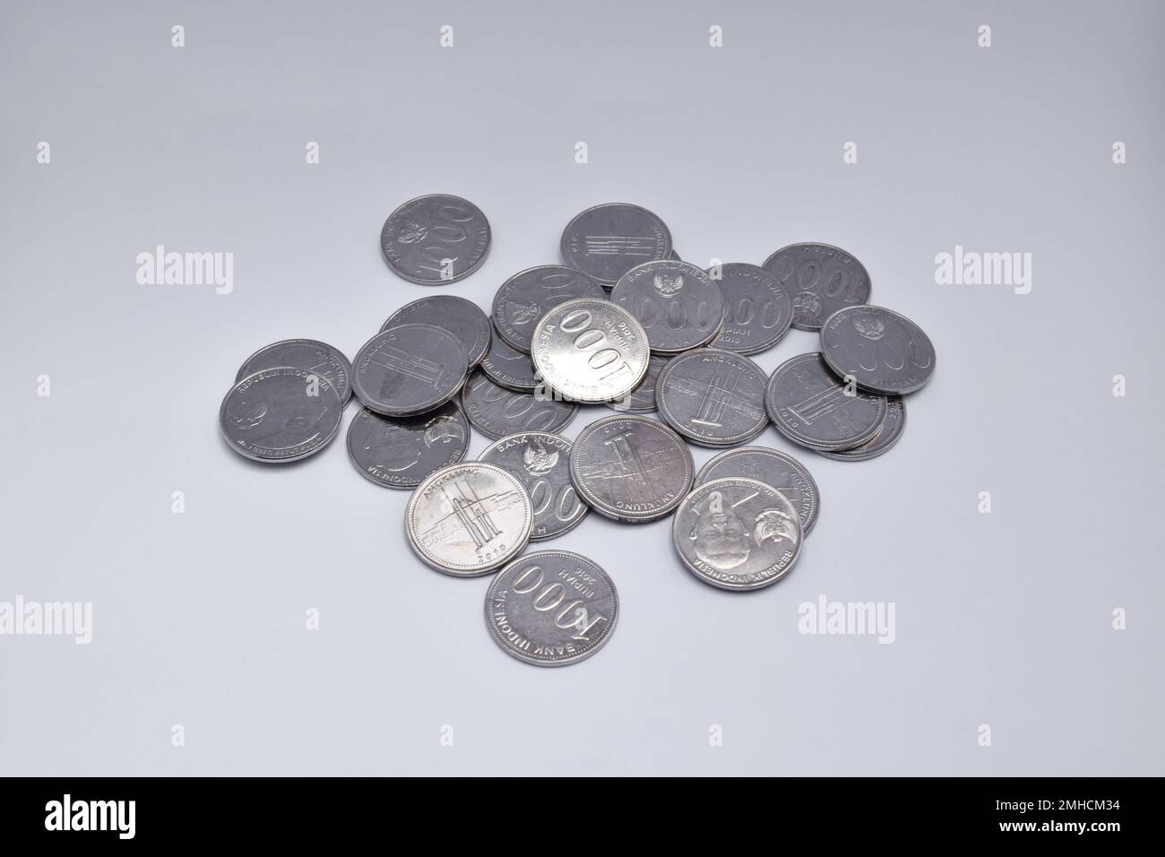 Pile of Indonesian thousand rupiah coins isolated on a white background ...