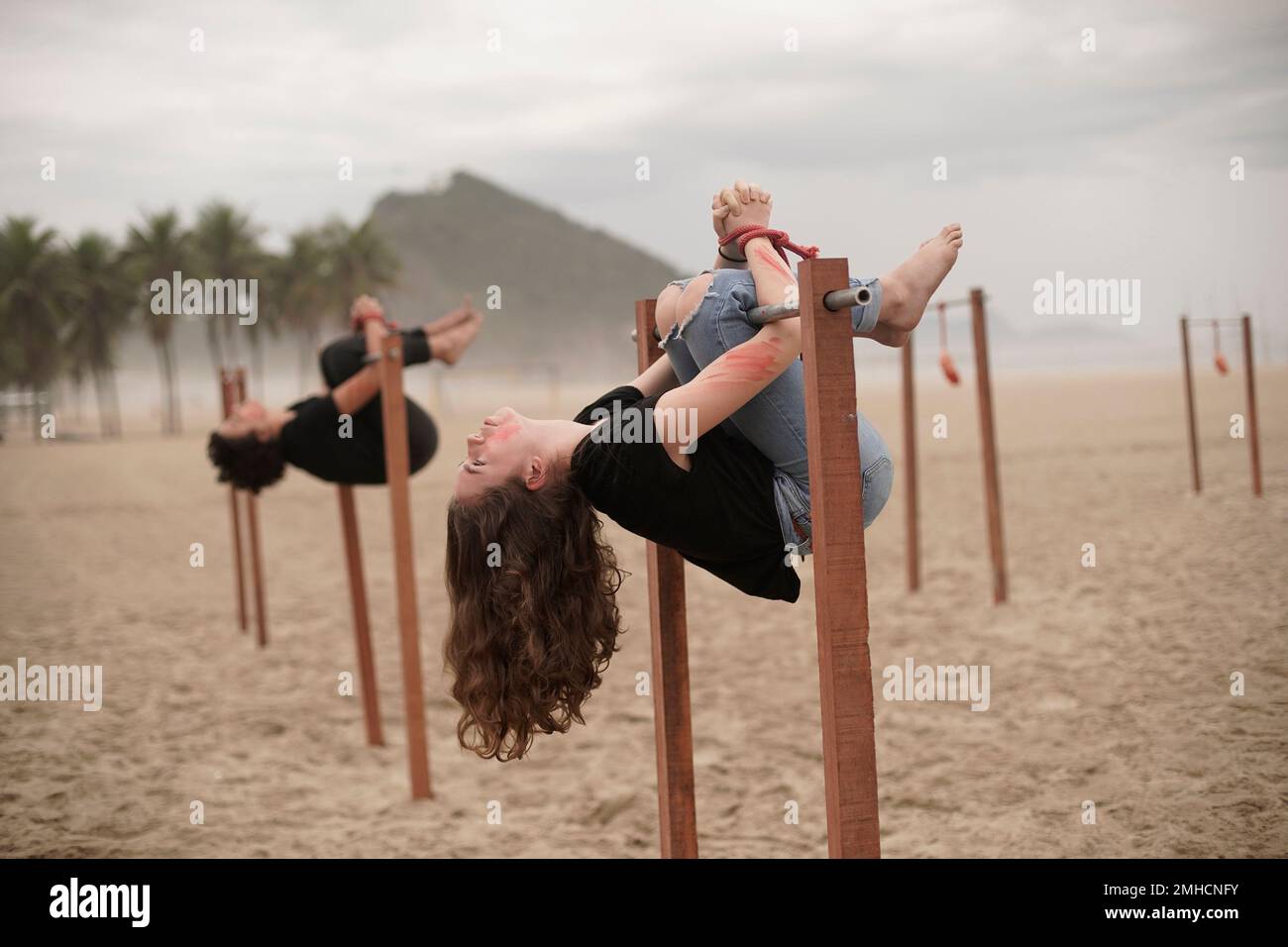 Demonstrators perform as victims in a torture device, called pau-de ...