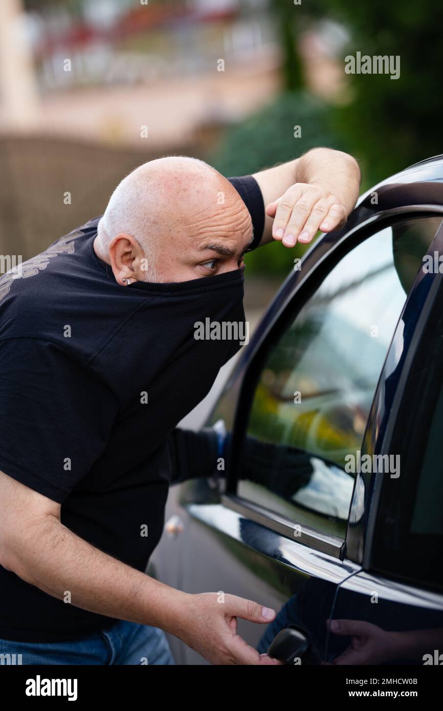 Thief stealing a car, robber. Car thief steal car breaking door ...