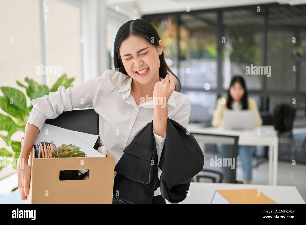 Happy and excited young Asian female office worker celebrating her ...