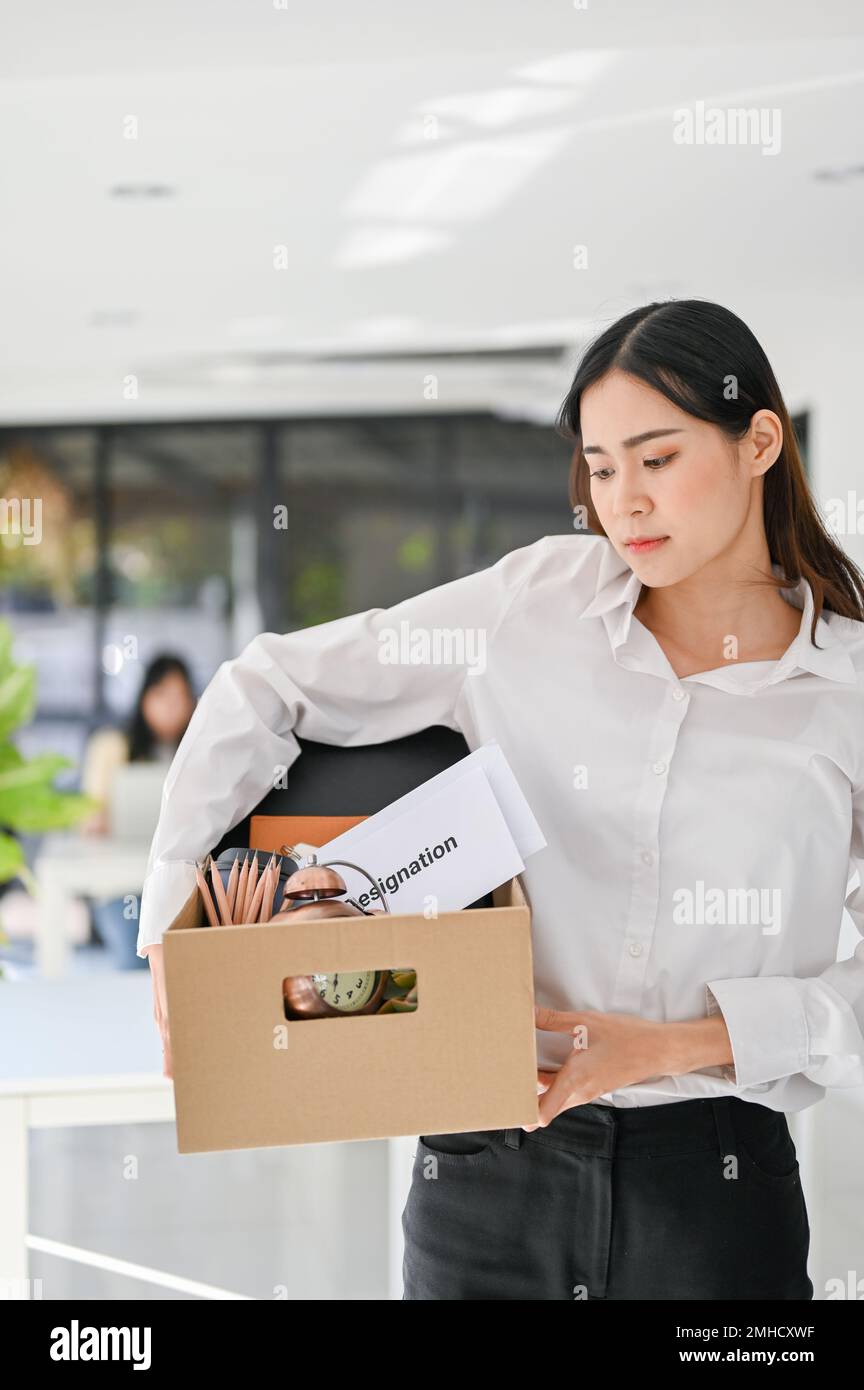 Portrait, Sad and upset young Asian female office worker carrying her ...