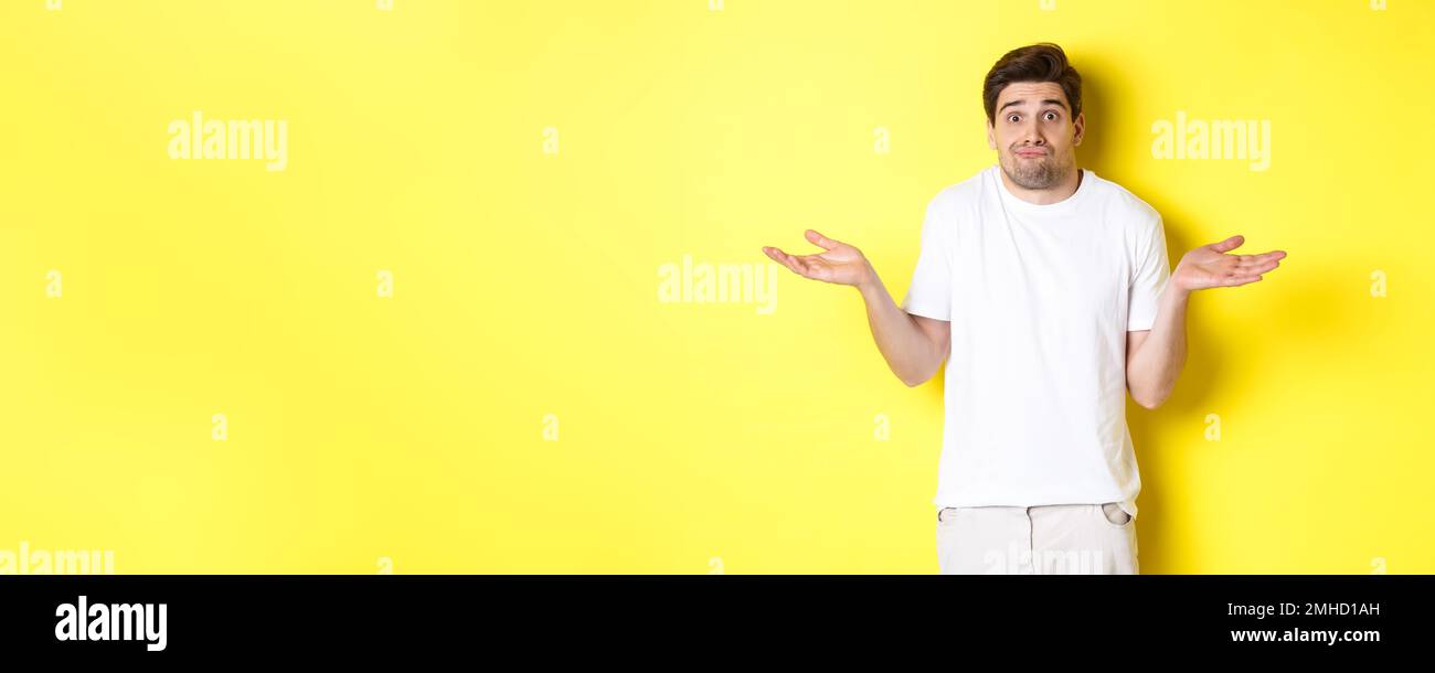 Clueless man shrugging, spread hands sideways confused, dont know ...