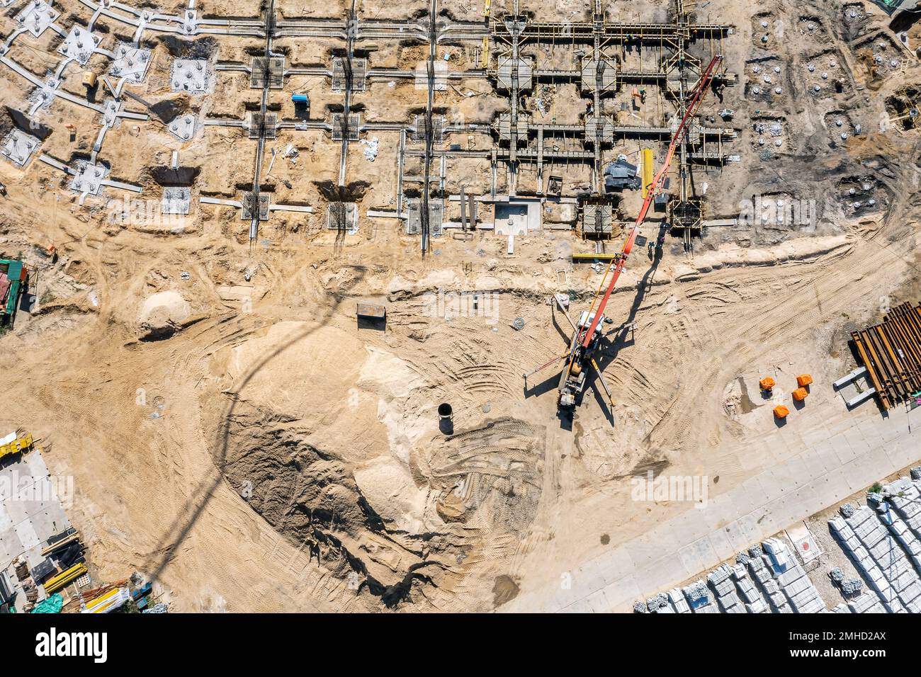 construction workers pouring wet concrete into foundation by concrete ...